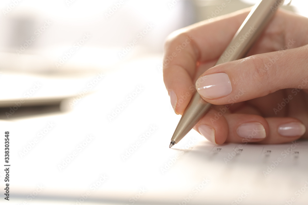 Woman hand filling out form with pen on a desk Stock Photo | Adobe Stock