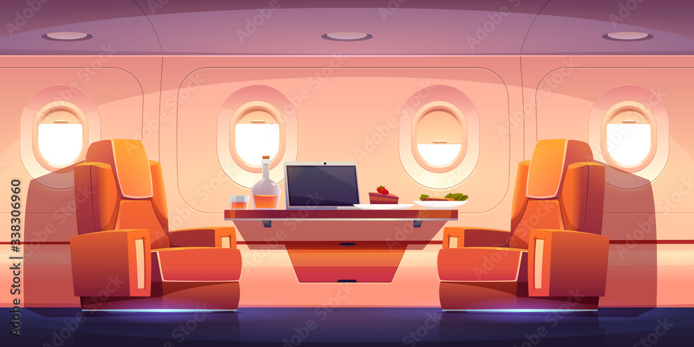 Luxury interior of private jet with armchairs, table with laptop, food ...