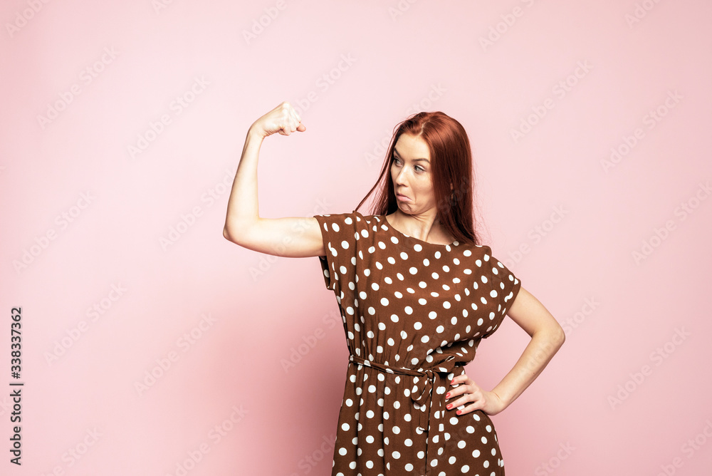 A redhead girl with the biceps. A strong girl with beautifull red hair ...