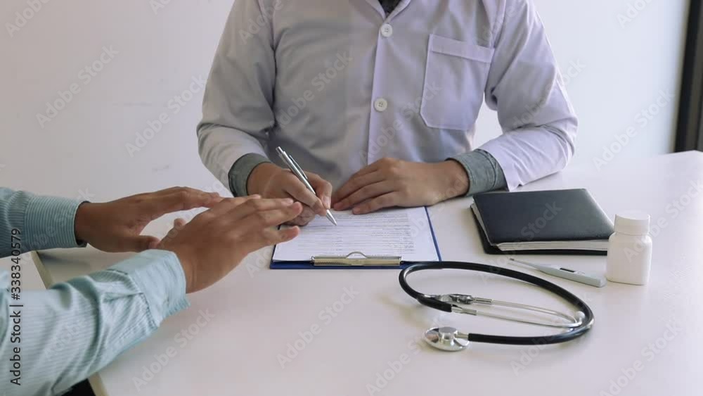 Doctor is recording the patient's information while the patient is ...