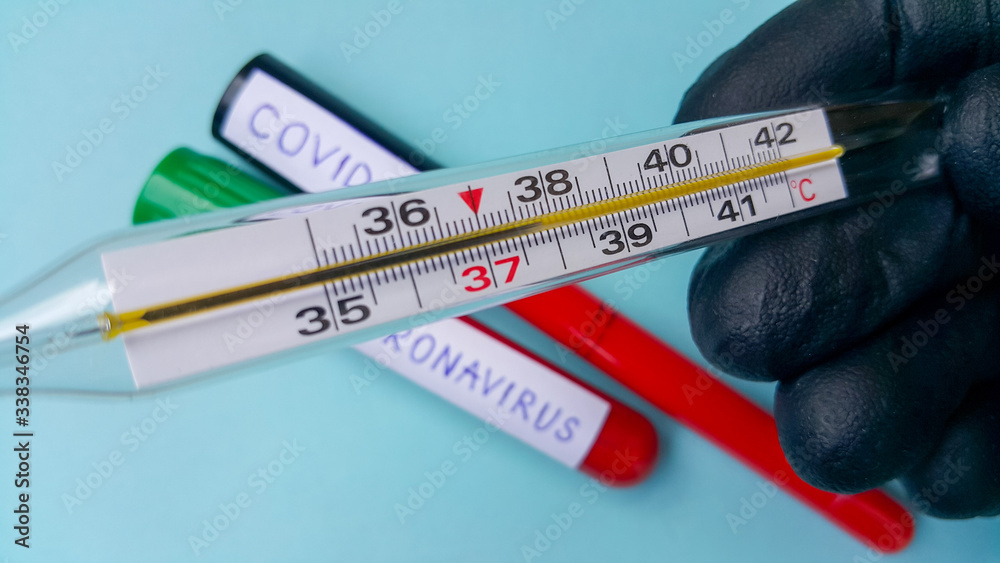 A thermometer showing a high temperature in the doctor's hand. In the ...
