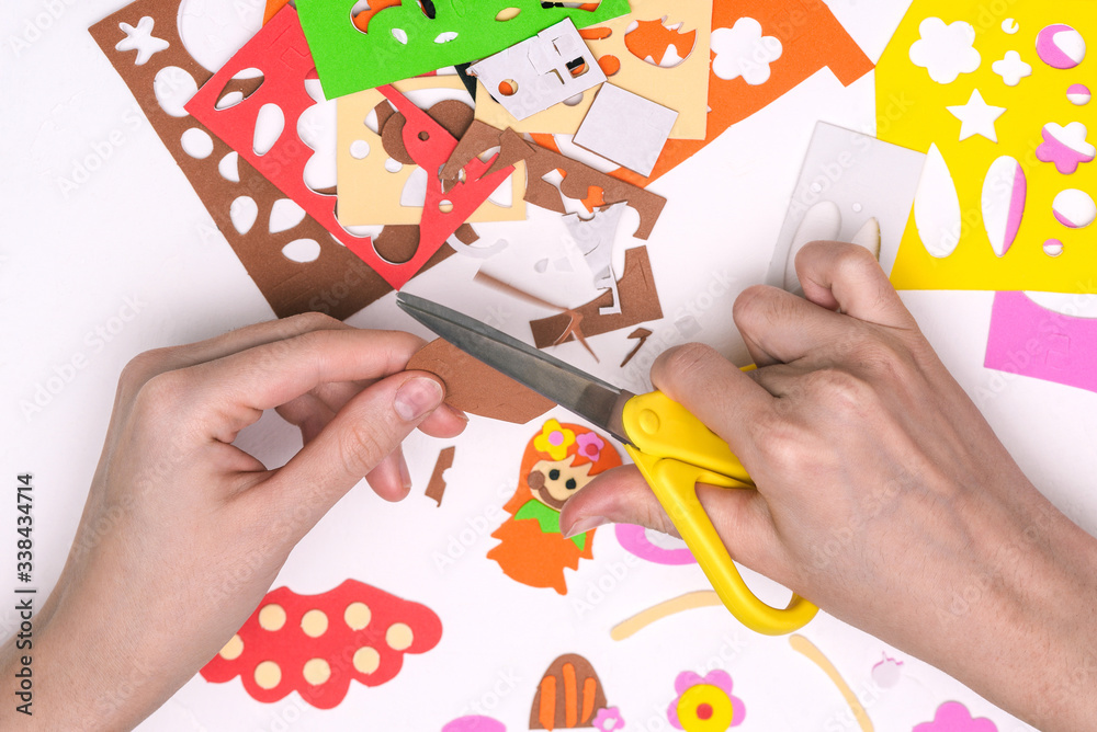 The human hand uses scissors to cut out figures from paper. Children's ...