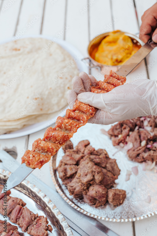 Process of making kebab. Meat on skewer. Cooker follow hygiene and use ...