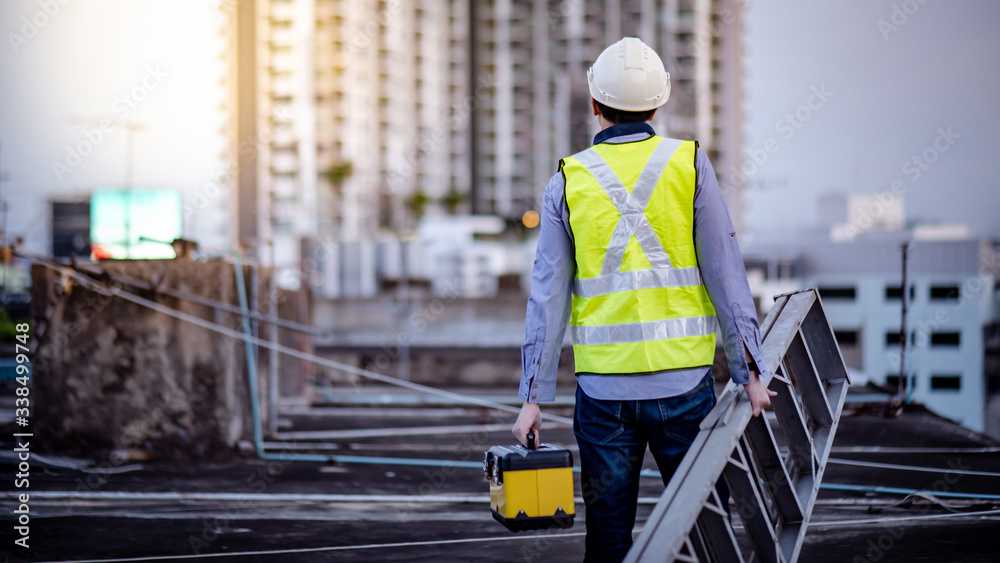 Asian maintenance worker man with safety helmet and green vest carrying ...