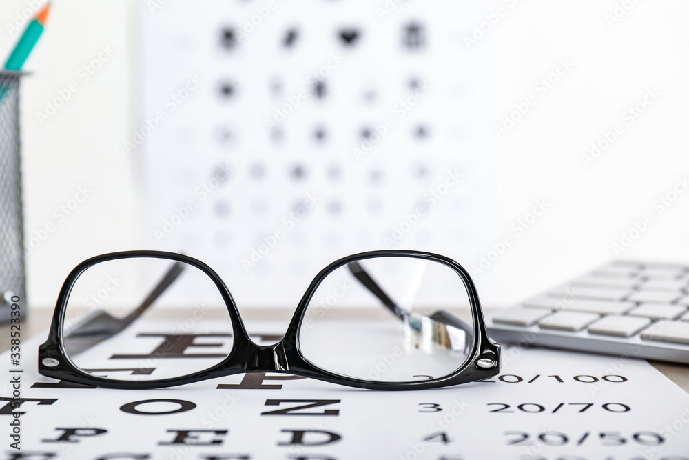 Eye test chart with eyeglasses on table, closeup Stock Photo | Adobe Stock