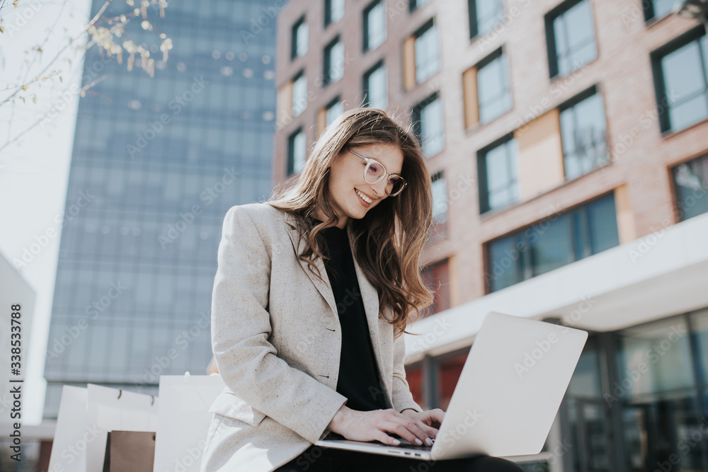 Beautiful lady with laptop and shopping bags, making online orders ...