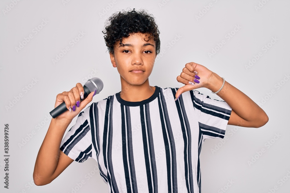 Beautiful african american afro singer woman singing using microphone ...