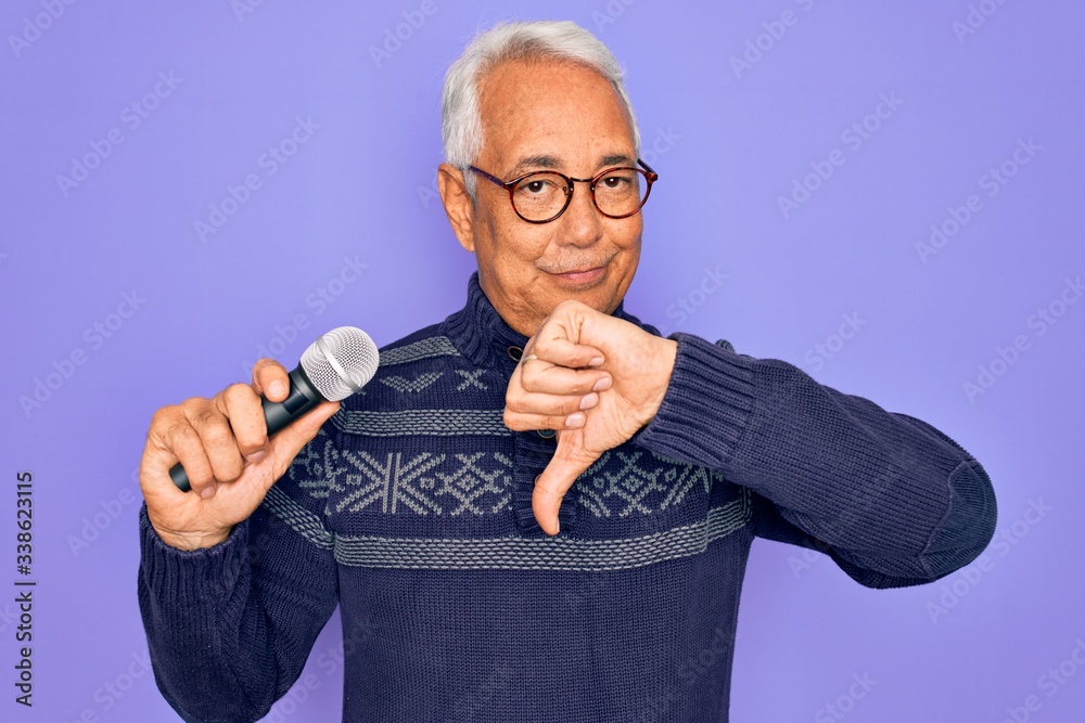 Middle age senior grey-haired singer man singing using music microphone ...