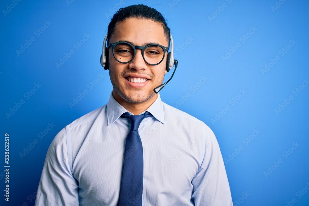 Young brazilian call center agent man wearing glasses and tie working ...