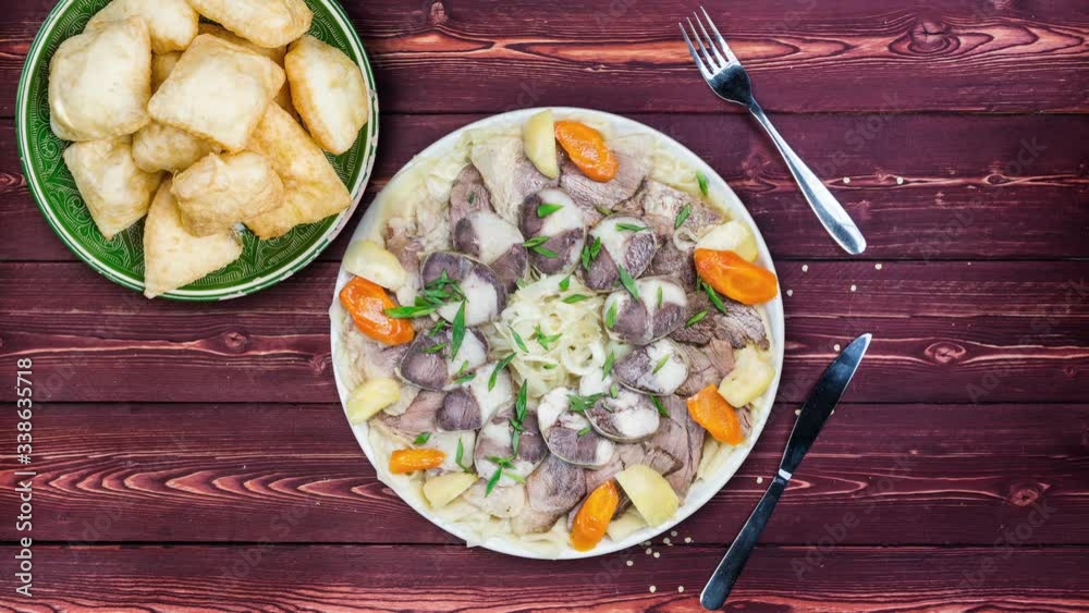 Beshbarmak dish with baursak rotates on a white plate - traditional ...