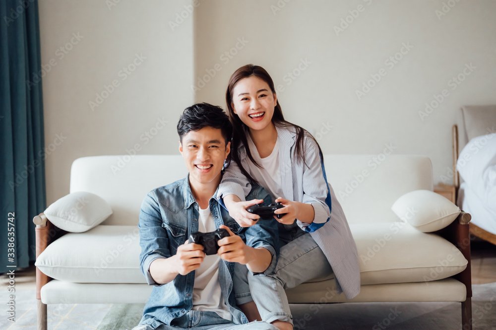Young Asian couple playing game at home Stock Photo | Adobe Stock