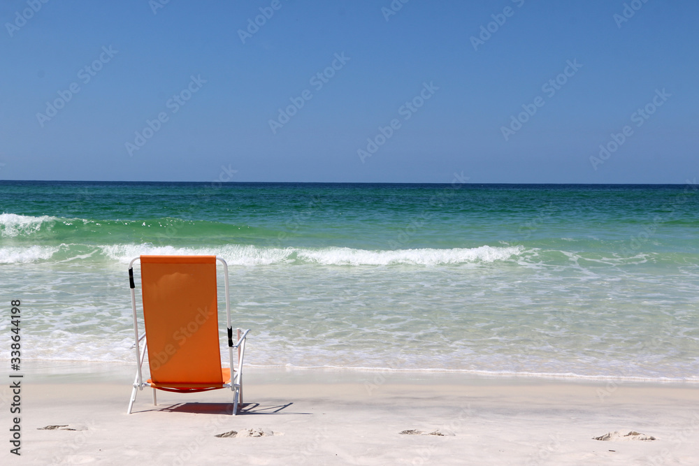 beach chair on beach facing ocean with waves and blue sky background ...