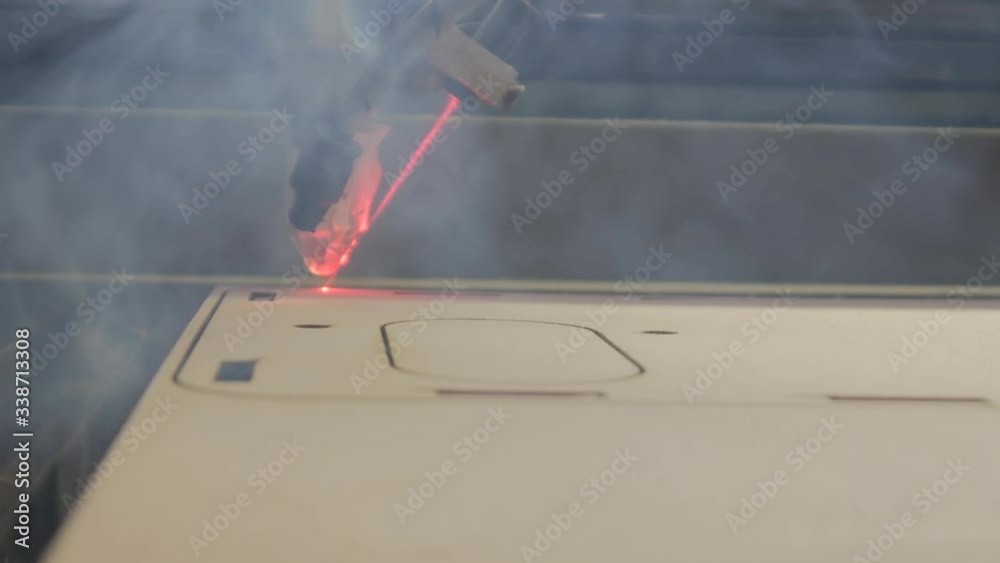 the machine's bright red laser beam cuts through the thick blue smoke ...