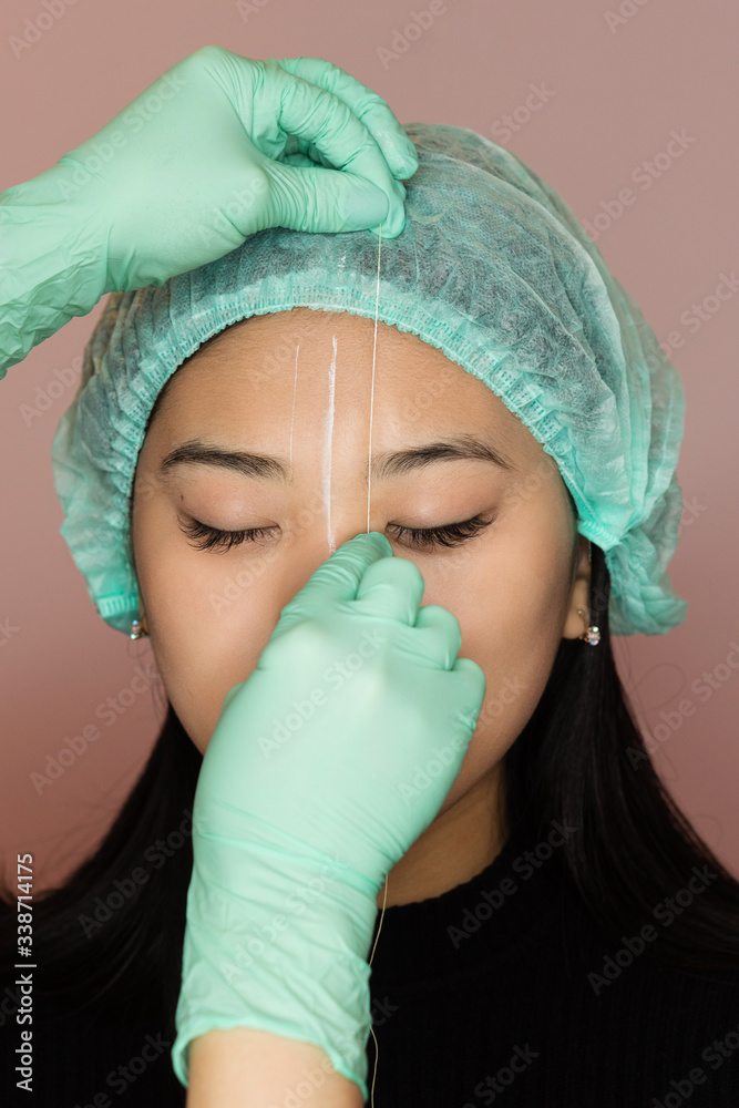 Microbleeding and eyebrow architecture. Beautician builds lines of ...