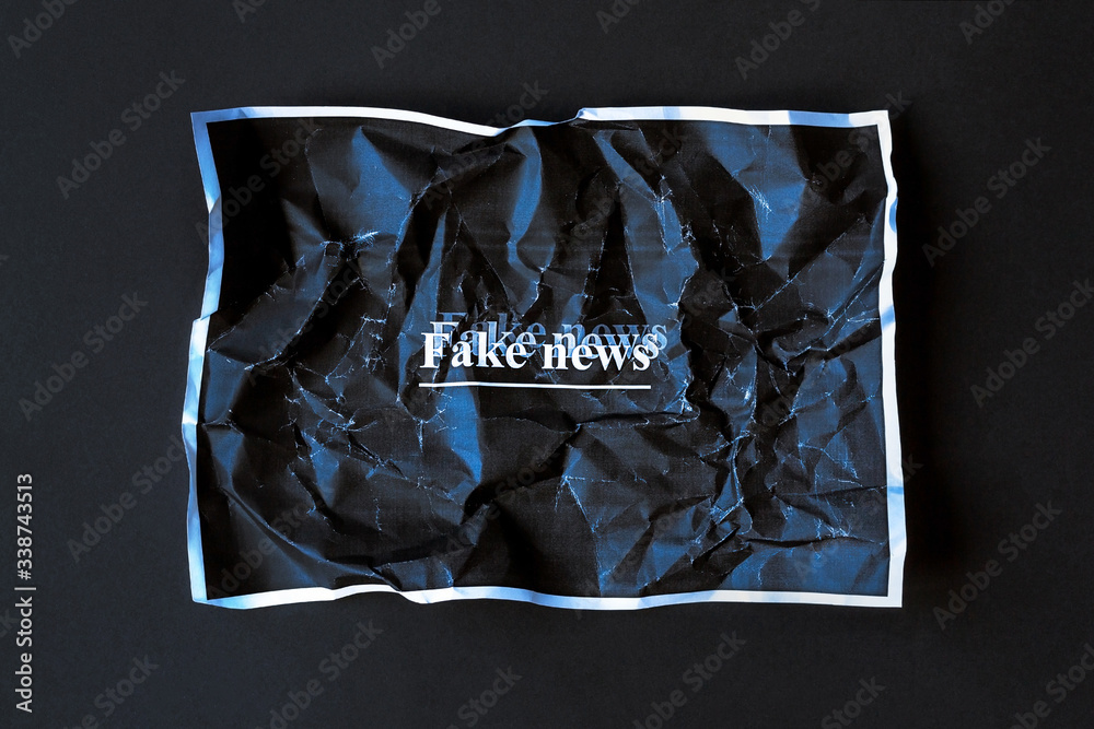 Paper sheet with Fake news inscription. Crumpled sheet of dark paper ...