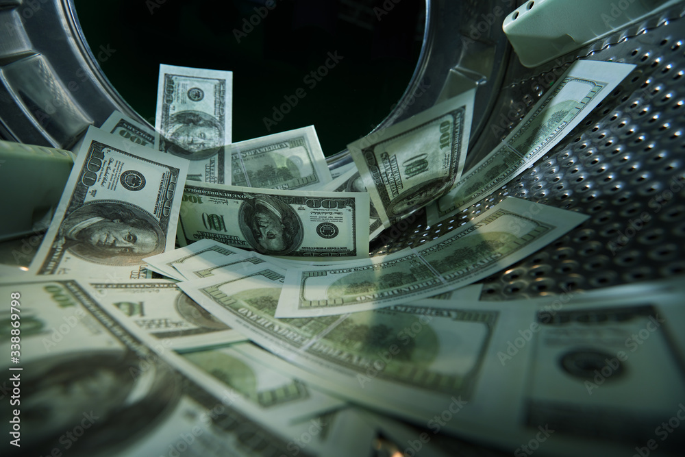 Washing banknotes in machine, money laundering, financial fraud concept ...