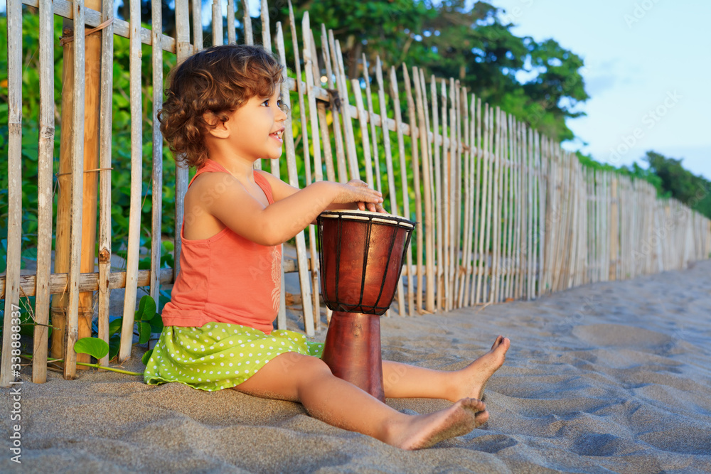 Little happy baby girl play ethnic music on traditional african hand ...