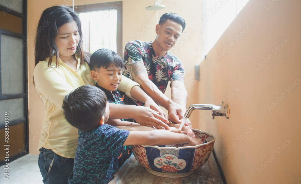 Asian family washing hands with soap in bathroom. Indonesian, malasian ...