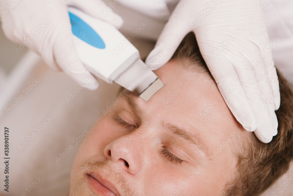 Cropped close up of a dermatologist using ultrasound cleaning device on ...