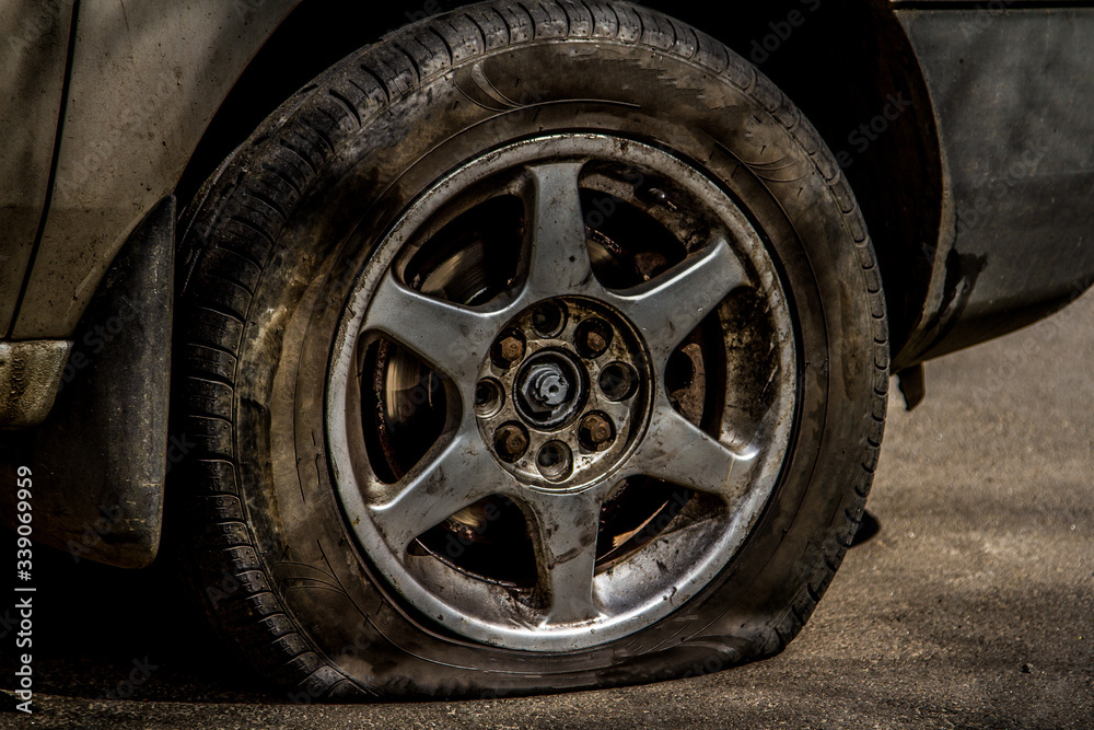 The deflated wheel of the car is close-up. The flat tire on the cast of ...