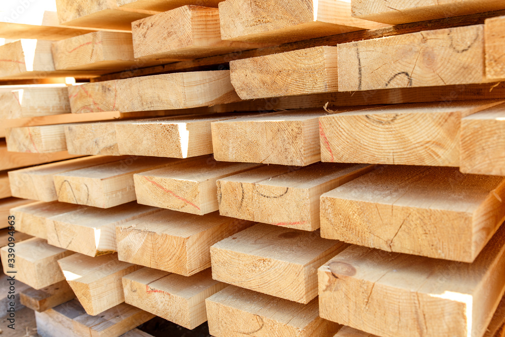 Stack of new wooden studs at the lumber yard. Timber on the ...