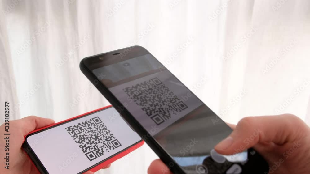 One person presents a smartphone with QR code pass to another person ...
