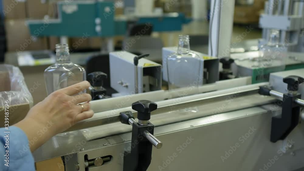 Time-laps of worker put plastic bottles on a conveyor belt. Female ...