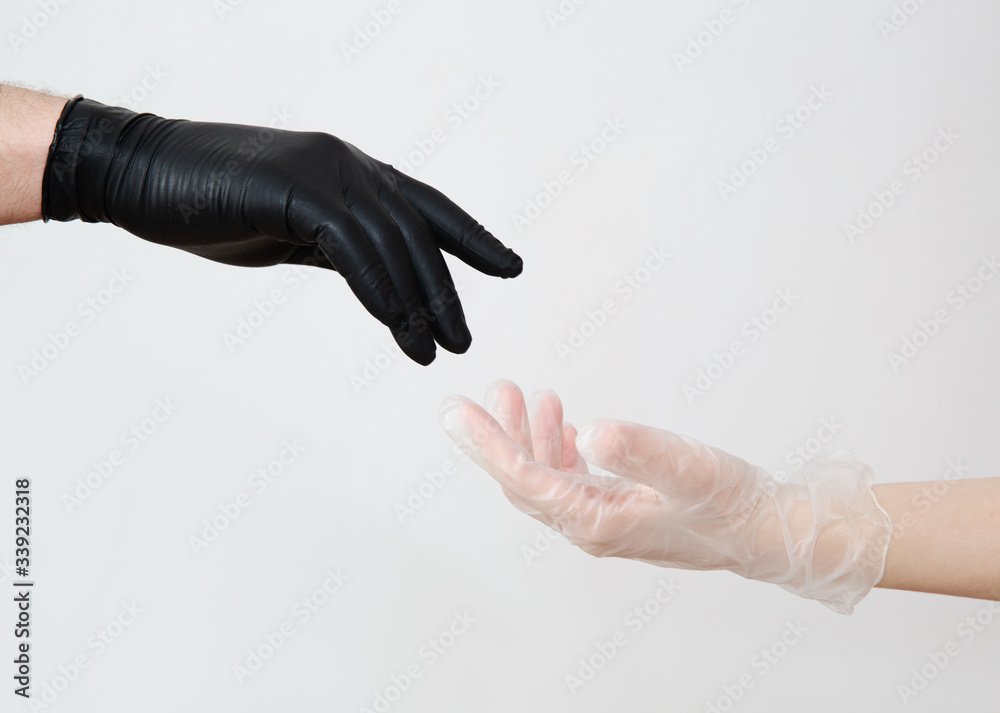 Â a hand in a black glove reaches for a hand in a transparent glove to ...