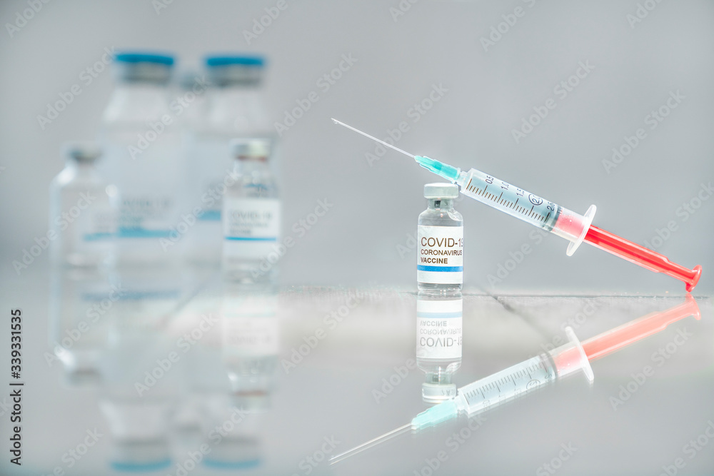 Reflections of vaccine bottles, syringe and other vaccine bottles on ...