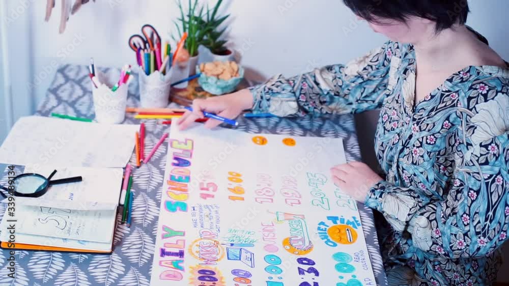 Home office, COVID 19. Woman makes daily schedule for children at home ...