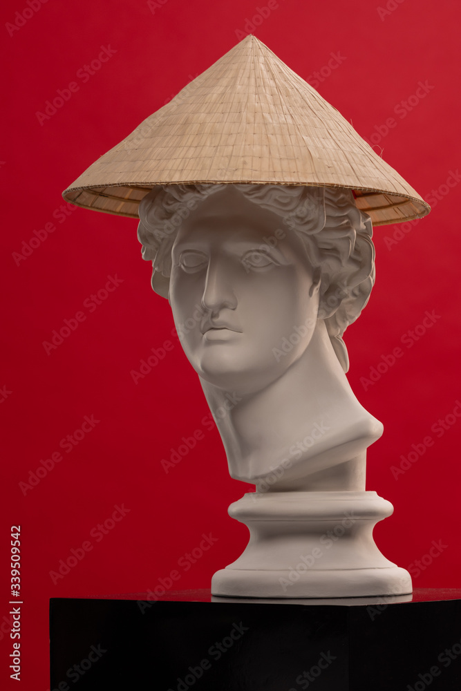 White plaster Statue of a bust of Apollo Belvedere in an Asian conical ...