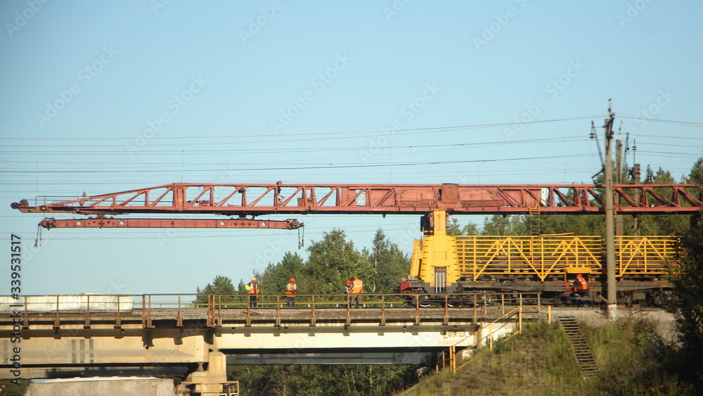 Russian rail stacker crane on a railway bridge, replacement of rails ...