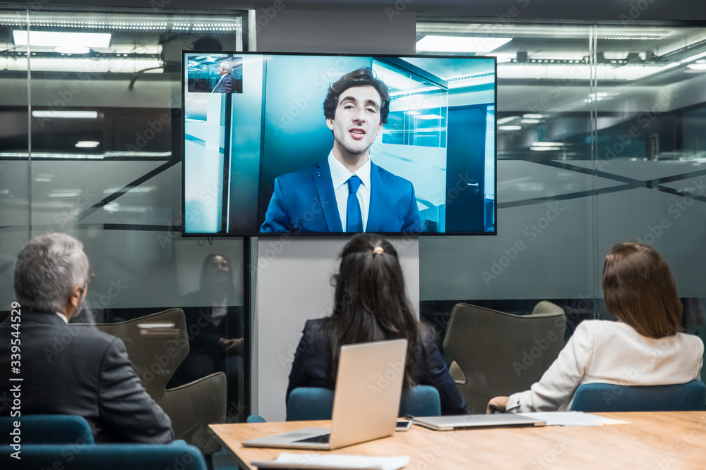 Employees listening to young leader during video conference. Business ...