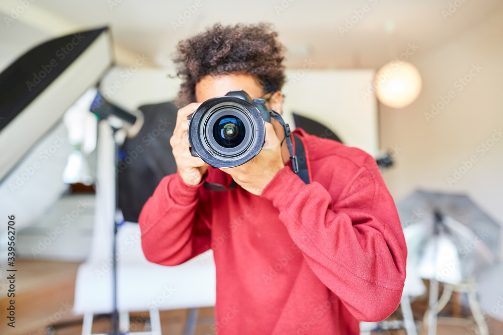 Young photographer with reflex camera in the studio Stock Photo | Adobe ...