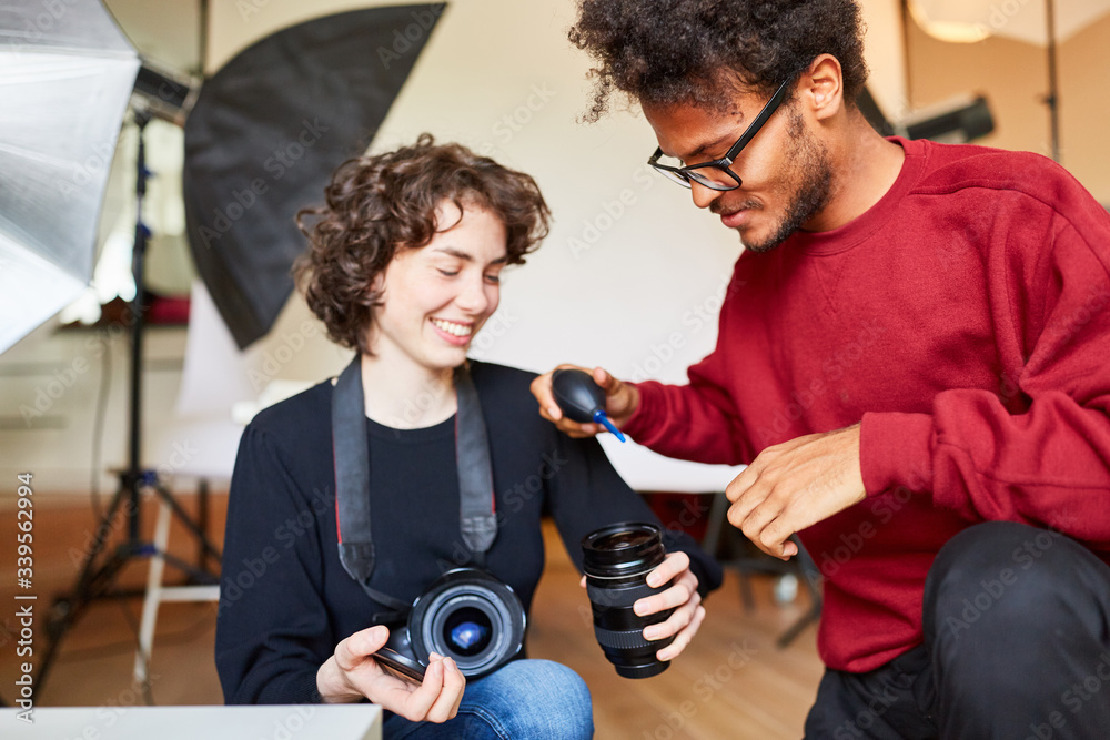 Photographer and photo assistant clean camera lens Stock Photo | Adobe ...