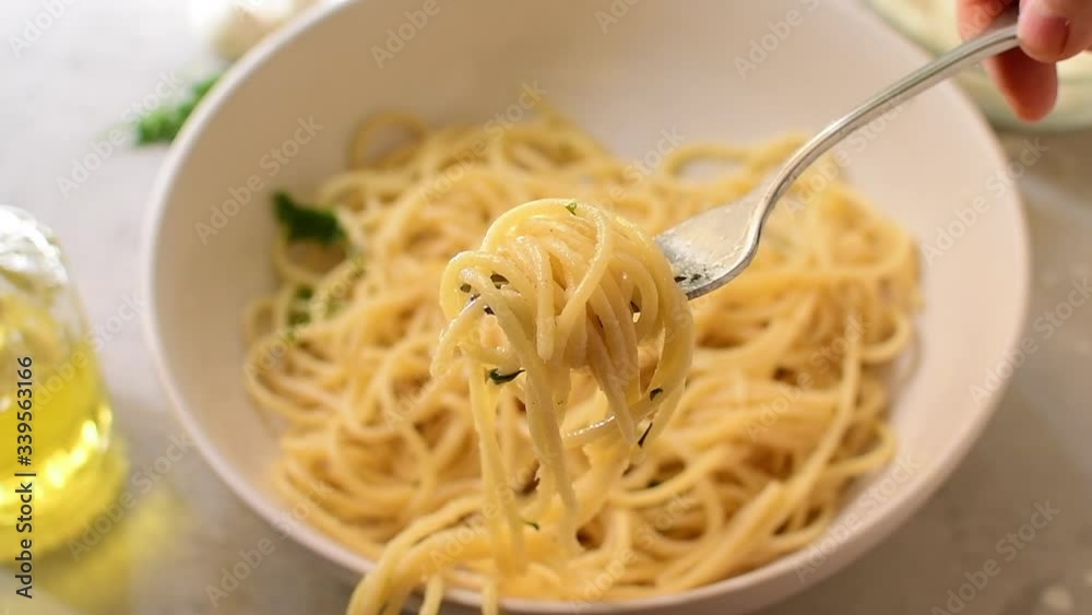hot spaghetti pasta with olive oil and Parmesan cheese on a fork ...