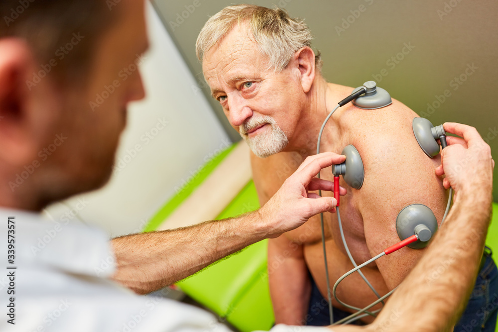 Orthopedist makes stimulation current therapy with senior patient Stock ...