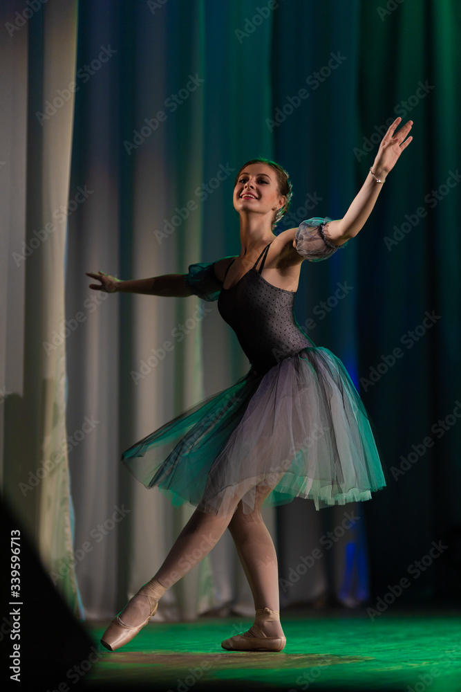 Young girl ballerina in a gray dress dancing ballet performance on ...