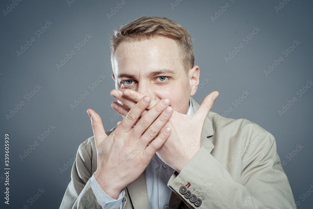 Closeup portrait of young business man closing mouth with hand, shocked ...
