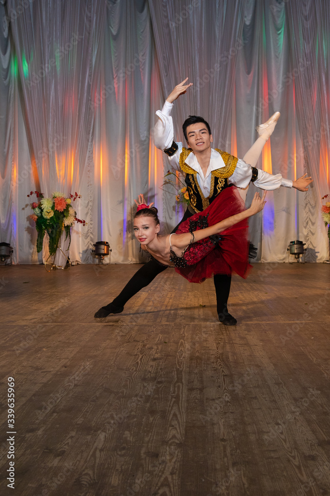 Duet young girl ballerina and a young man dancing ballet performance on ...