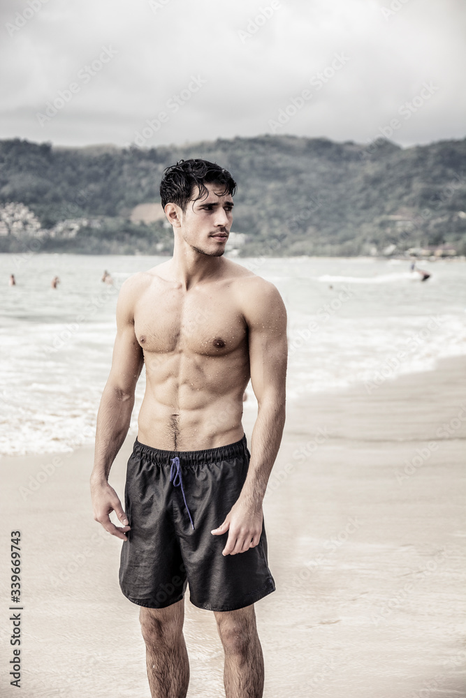 Half body shot of a handsome young man standing on a beach in Phuket ...