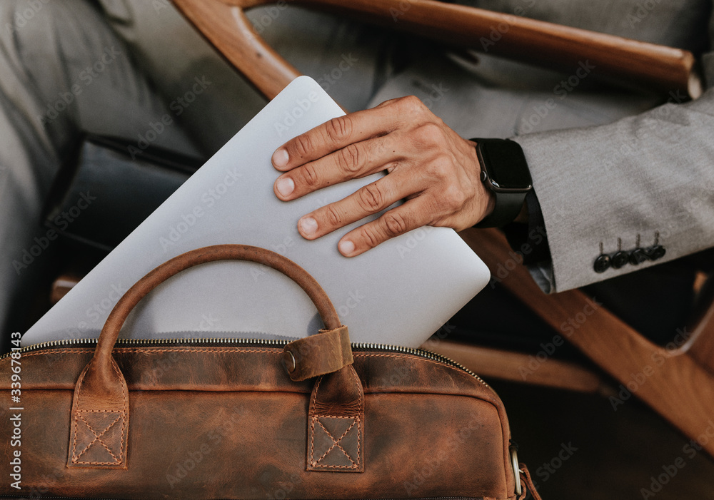 Businessman putting laptop on his bag Stock Photo | Adobe Stock