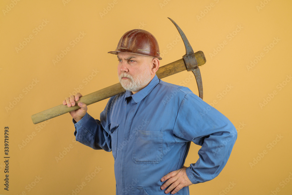Male bricklayer in hard hat with pickaxe. Construction worker holds ...