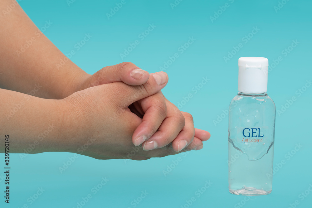 Desinfectándose las manos con gel antibacterial sobre un fondo de color ...