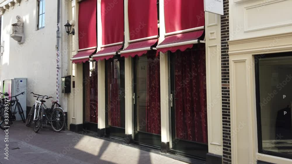Slow pan left to right of four windows in the red-light district with a ...
