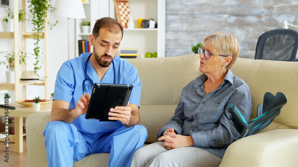 Doctor assistant taking notes on clipboard while listening to old ...
