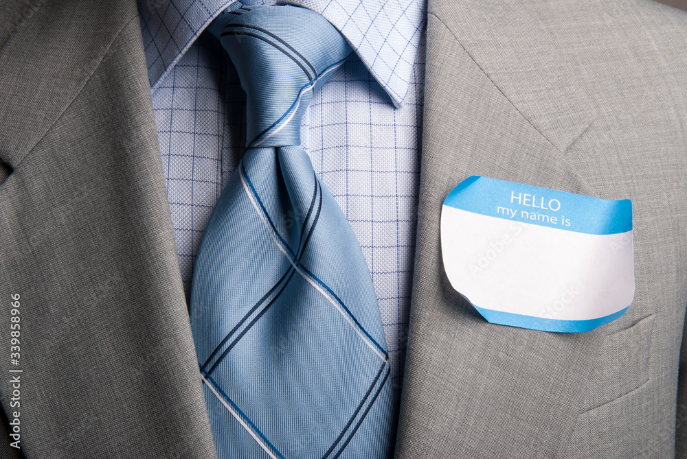 Close-up of a blank name tag peeling off the lapel of the suit of an ...