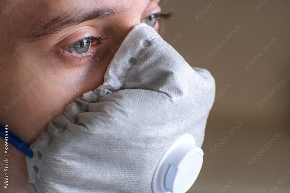 The young man's face is covered by a respirator with an exhalation ...