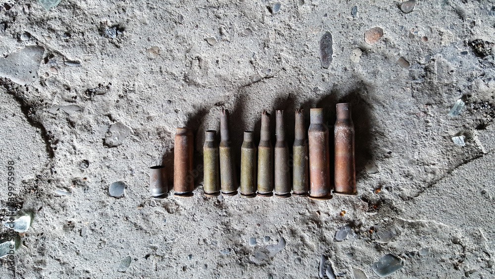 Casings from various types of weapons lying on a concrete slab Stock ...