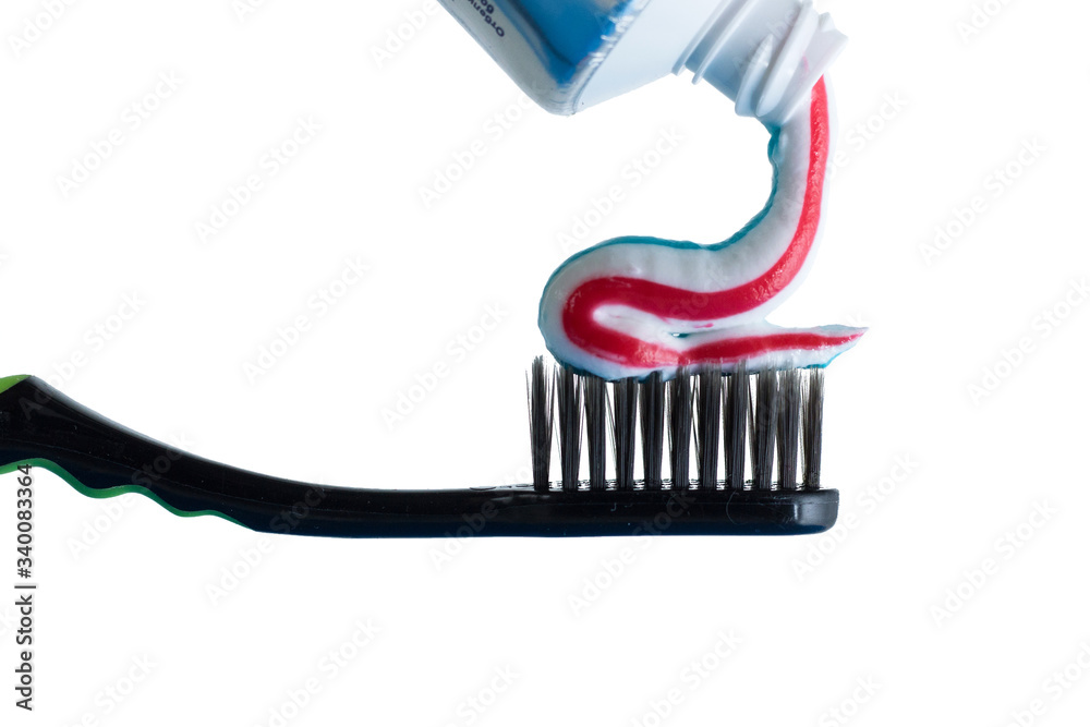 Toothpaste is applied to the toothbrush. Multi-colored toothpaste and ...